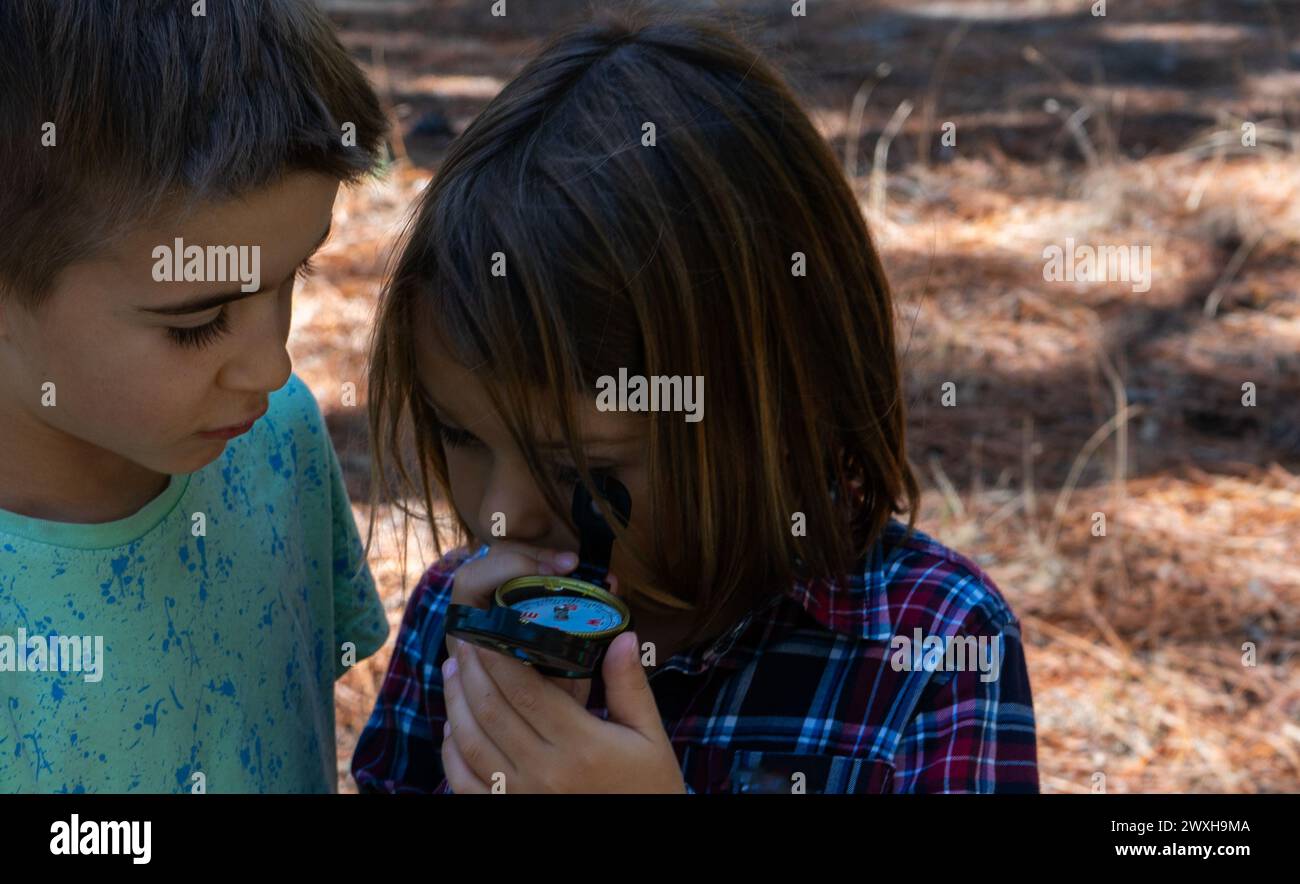 Two children in the woods looking at a compass Stock Photo - Alamy