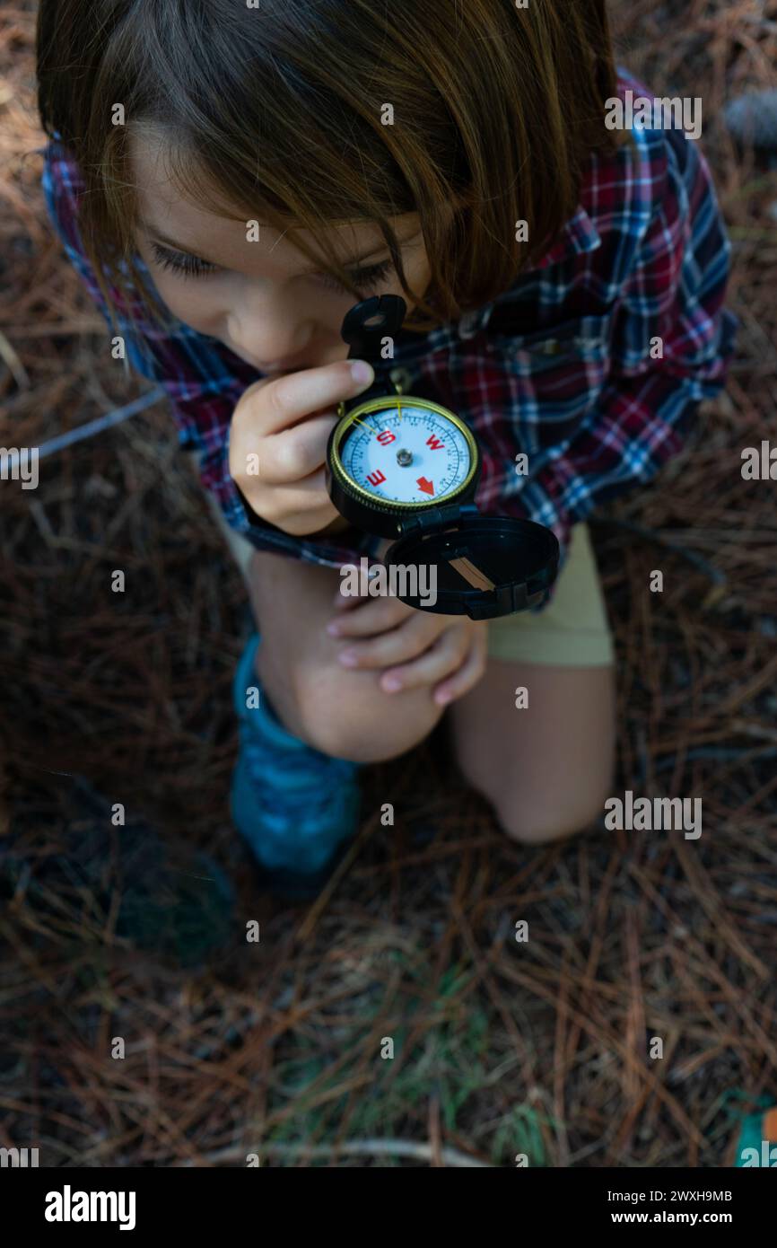 Child looking at a compass in the forest seen from above Stock Photo ...