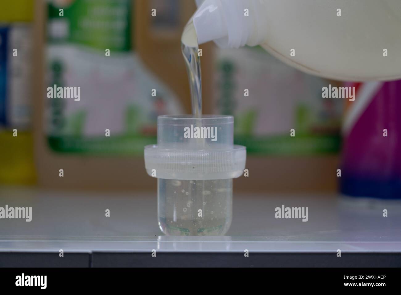 Laundry detergent in the measuring cup Stock Photo - Alamy