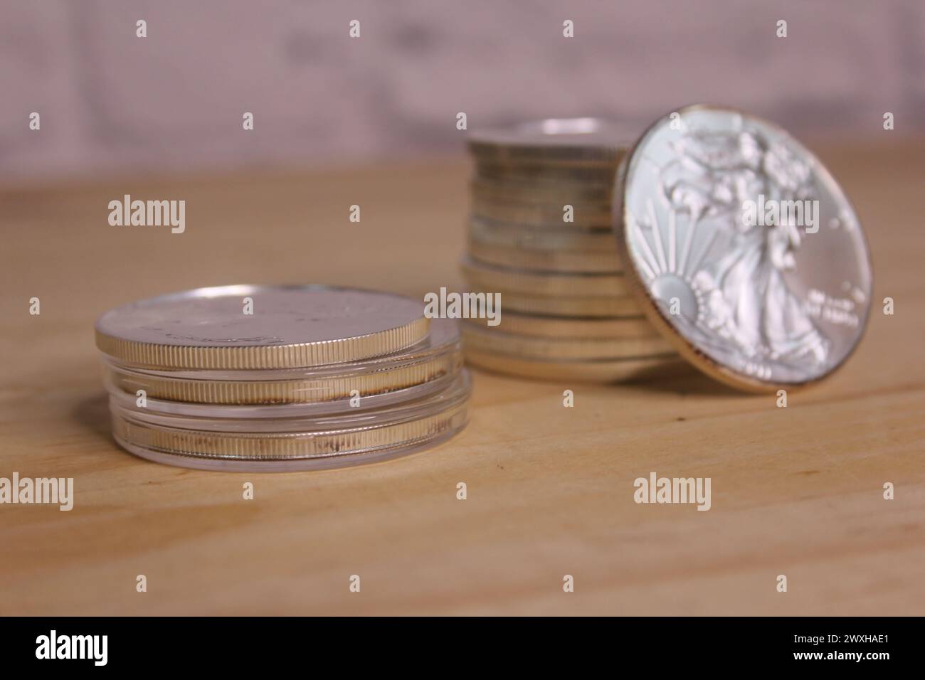 A pile of four quarters atop various coins, one being removed Stock ...