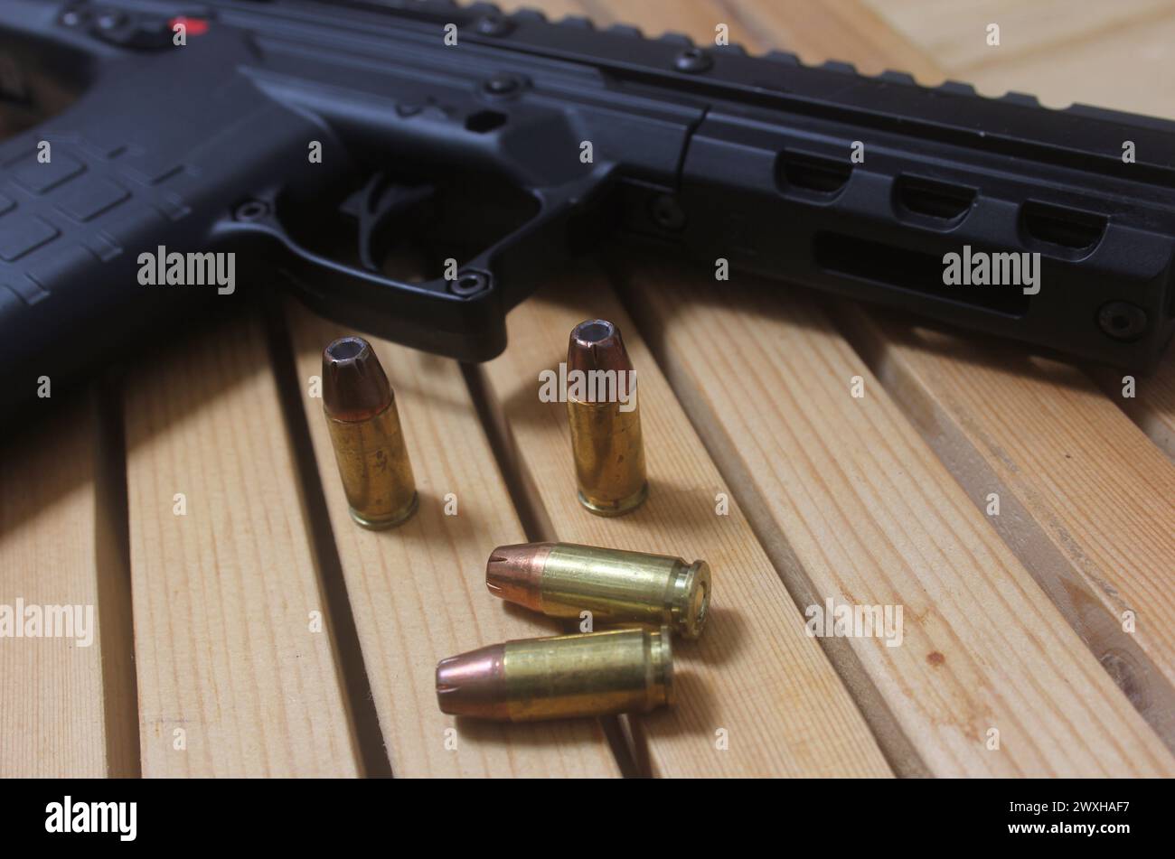 A gun resting on bullet casings on a table Stock Photo - Alamy