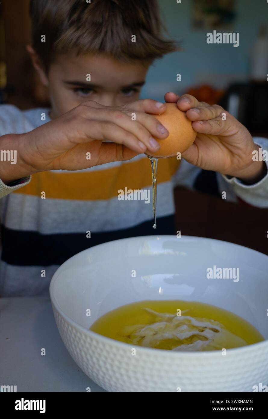 Child putting a raw egg in a bowl to cook a cake Stock Photo - Alamy