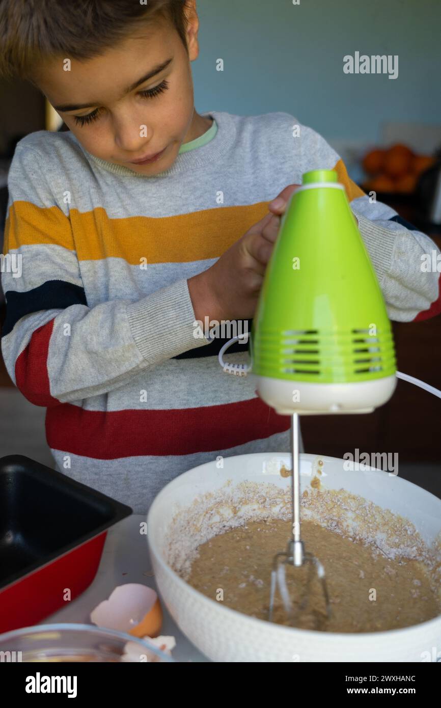 Child mixing the ingredients of a cake with an electric rod Stock Photo ...