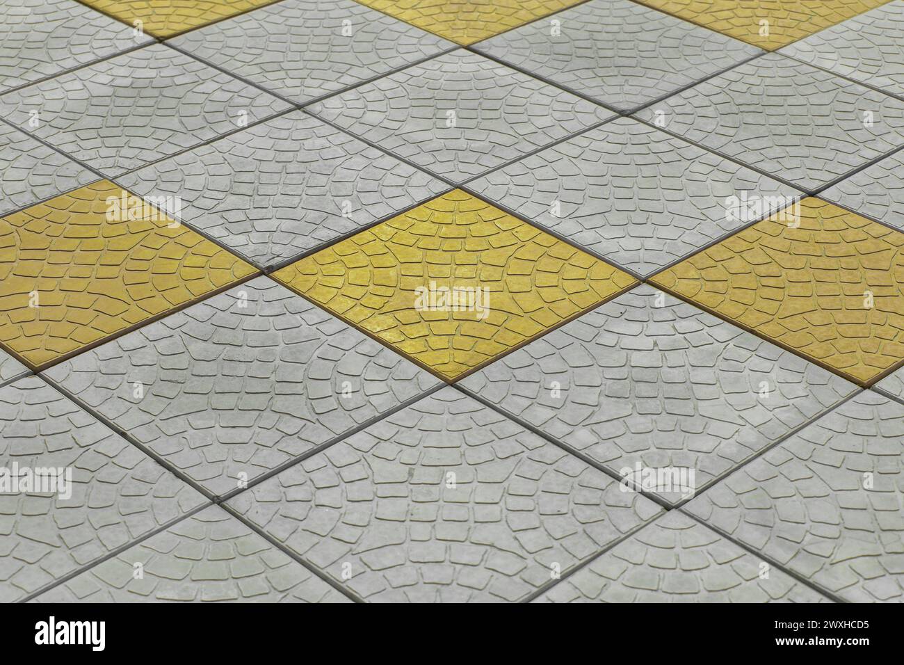 Diagonal pattern grey and yellow paving slabs floor road surface street ...