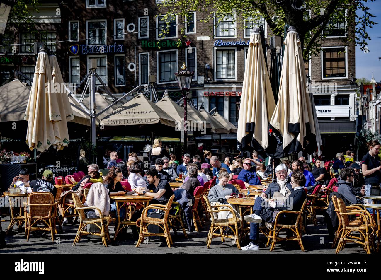 AMSTERDAM - Tourists sit on a terrace in the sun in the center on ...