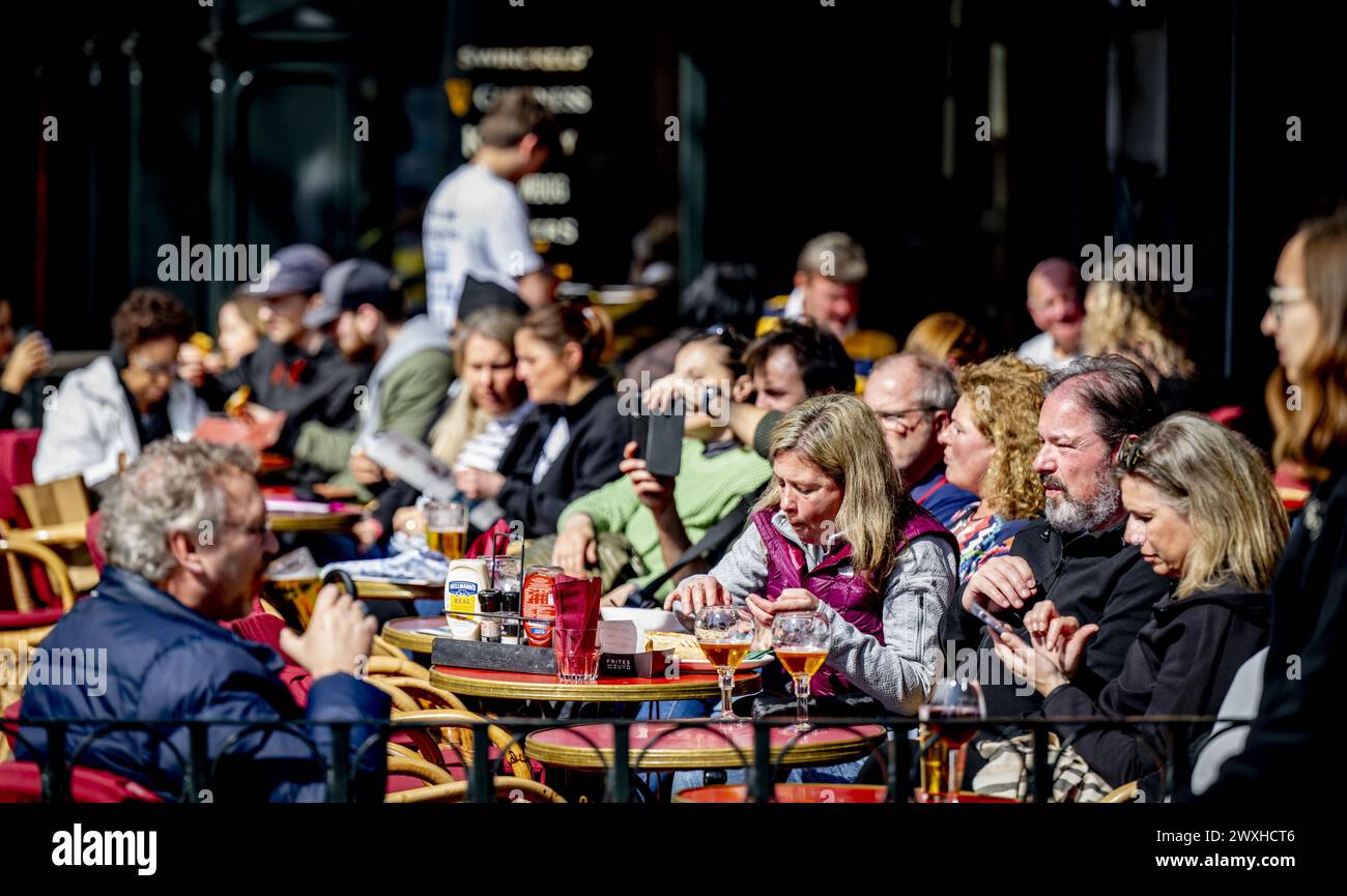 AMSTERDAM - Tourists sit on a terrace in the sun in the center on ...