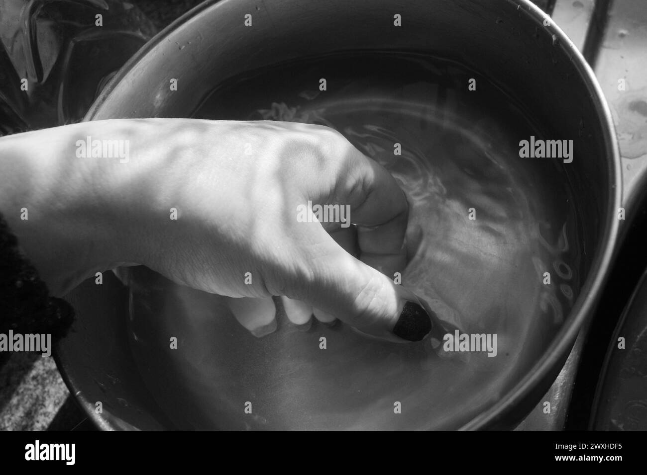 Washing ones hand - black and white shot of a hand in interior of a ...