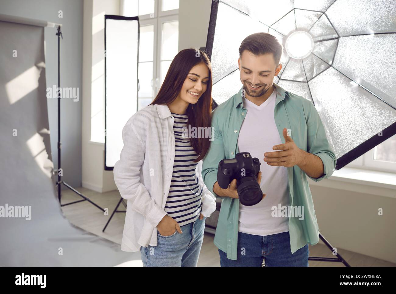 Professional male photographer showing photos to a girl model on ...