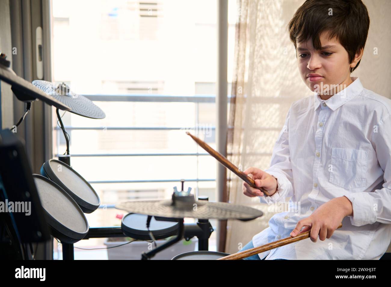 Handsome teen boy playing musical percussion instrument with sticks ...