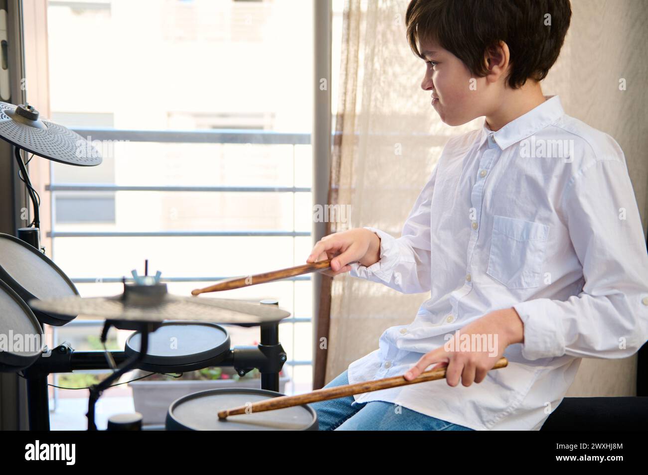 Authentic portrait of a Hispanic teenager boy using drumsticks, beating ...