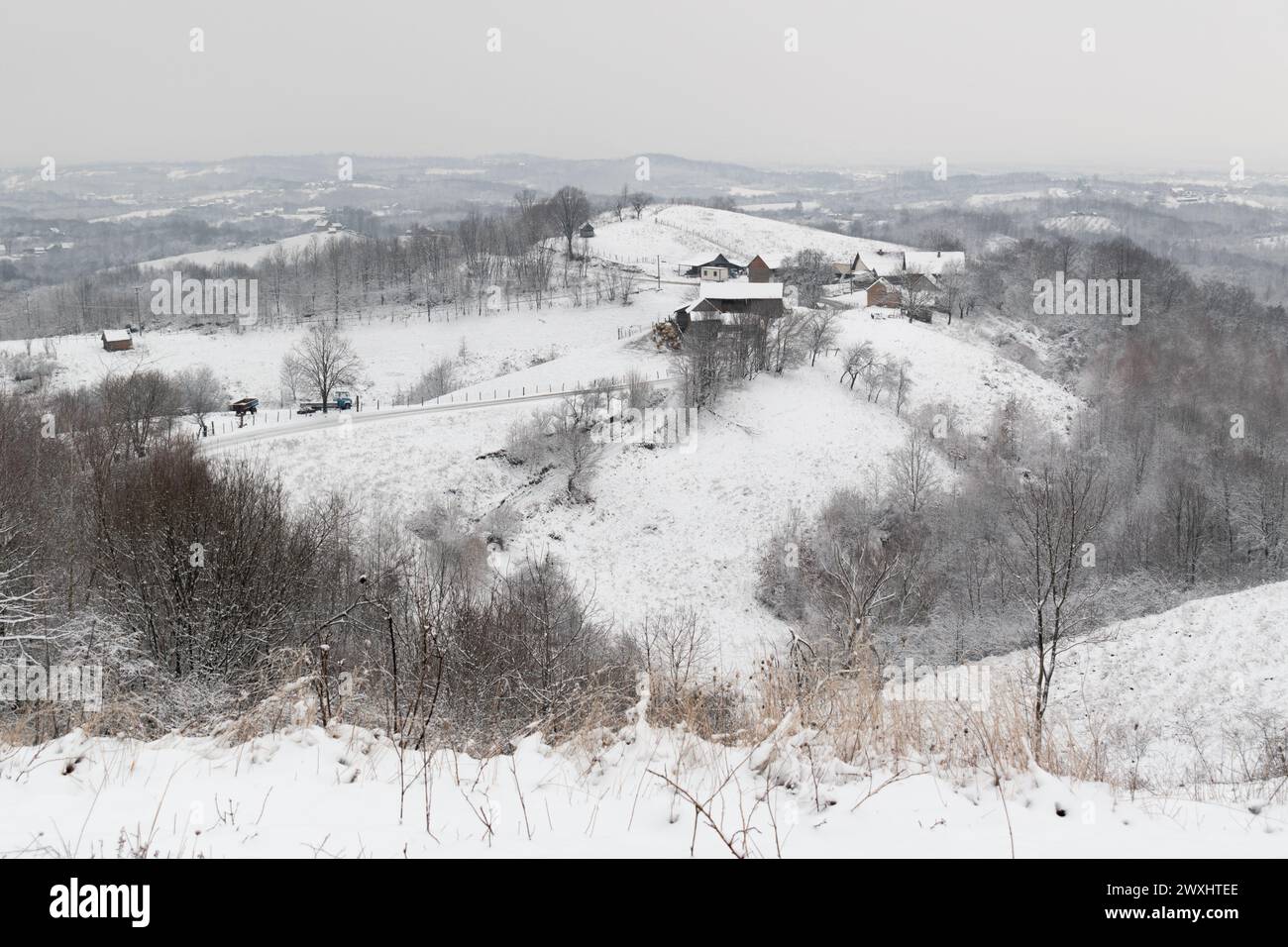 Farm on hill in winter, hilly village landscape during cold day with ...