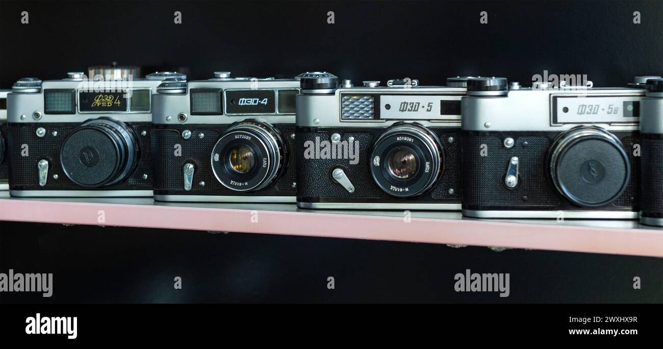 SAMARKAND, RUSSIA - SEPTEMBER 12, 2022: Old Soviet cameras FED-4 and FED-5 on a shelf on a black ...