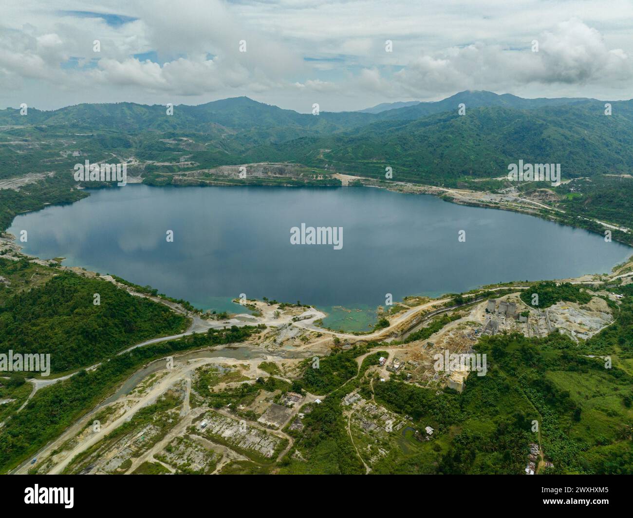 An artificial lake in an abandoned mining quarry. Quarry pond with ...