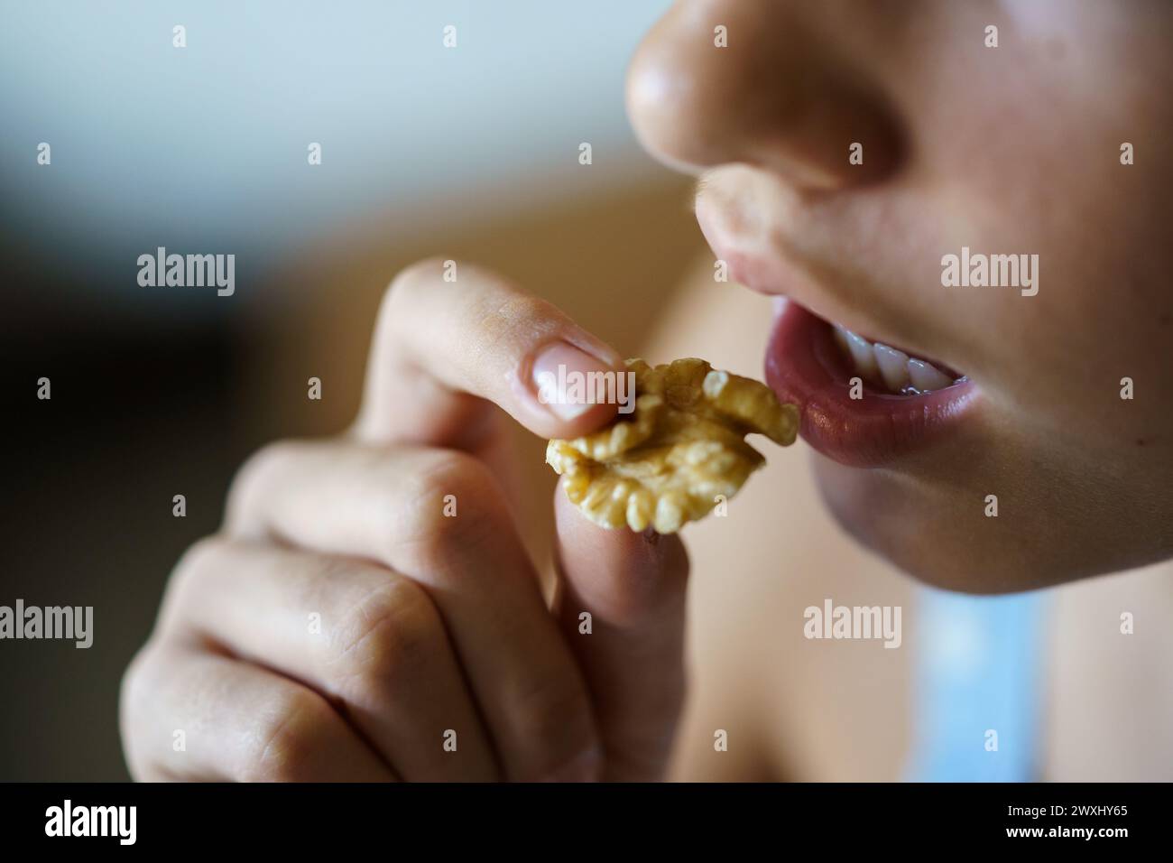 Crop anonymous teenage girl eating healthy walnut kernel Stock Photo ...