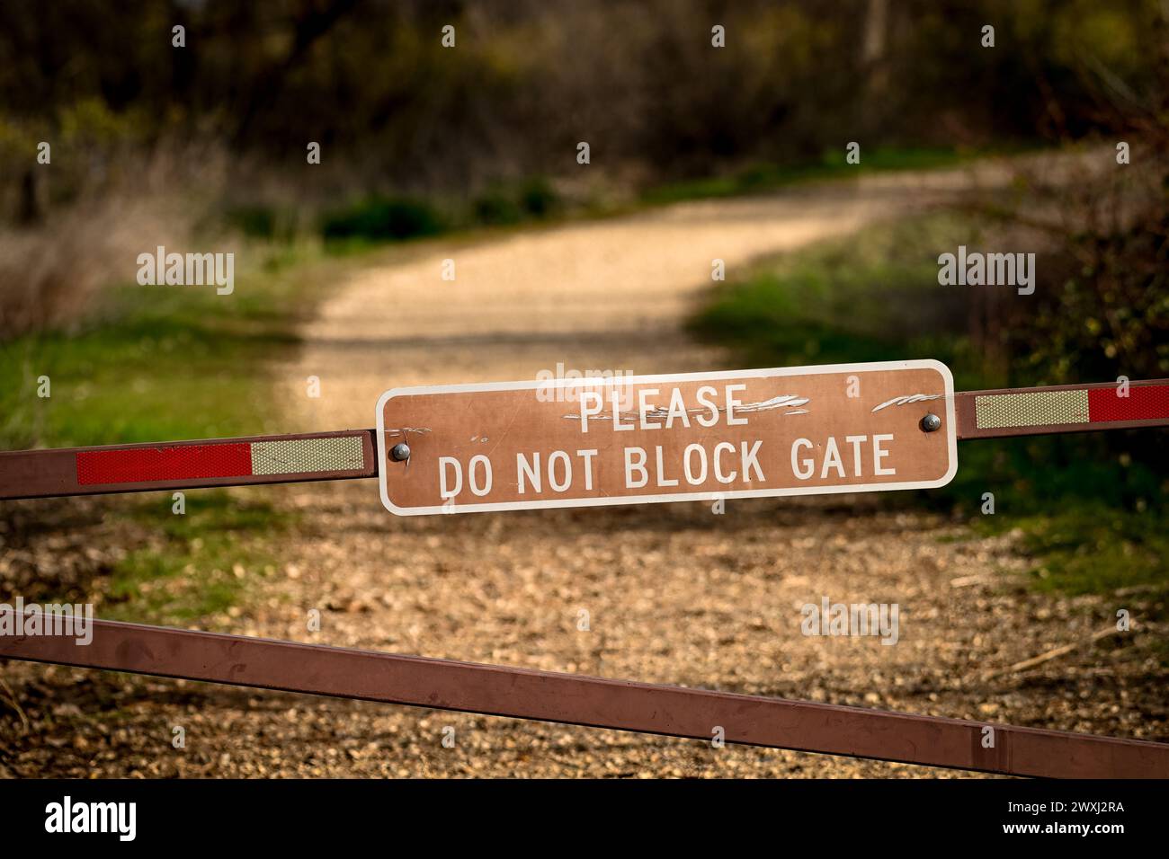 Warning sign about blocking a gate mounted on a gate Stock Photo - Alamy