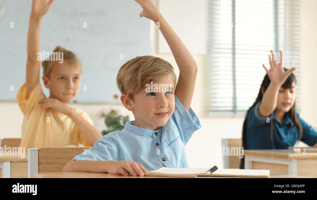 Caucasian boy raising hand for asking and answering teacher surrounded ...
