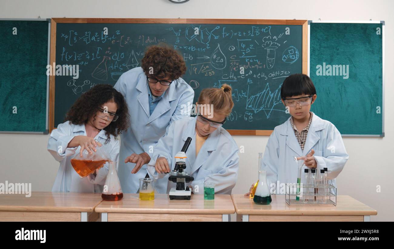Children doing experiment in science lesson while standing at ...