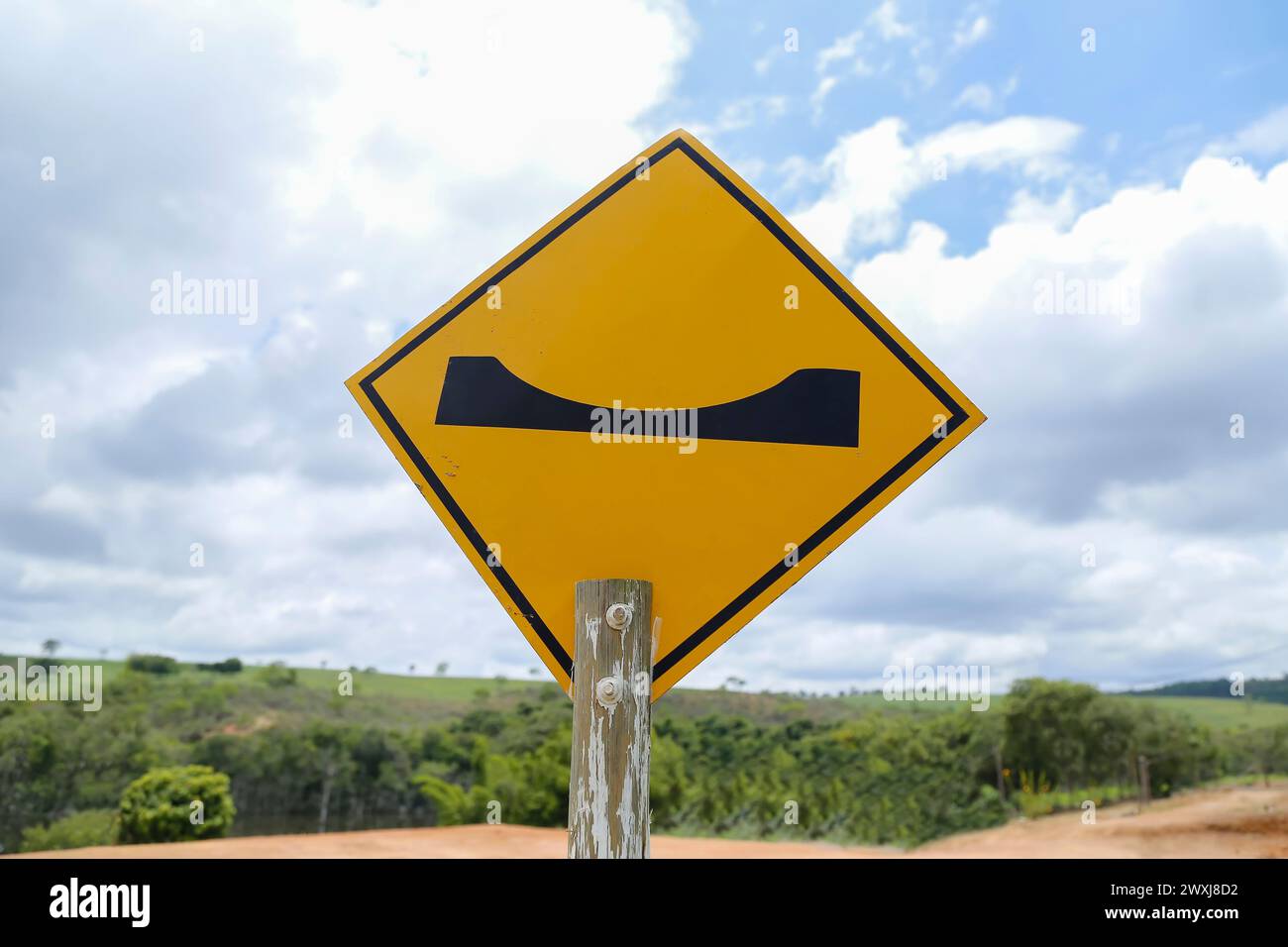 yellow traffic sign indicating depression ahead - warning and danger ...