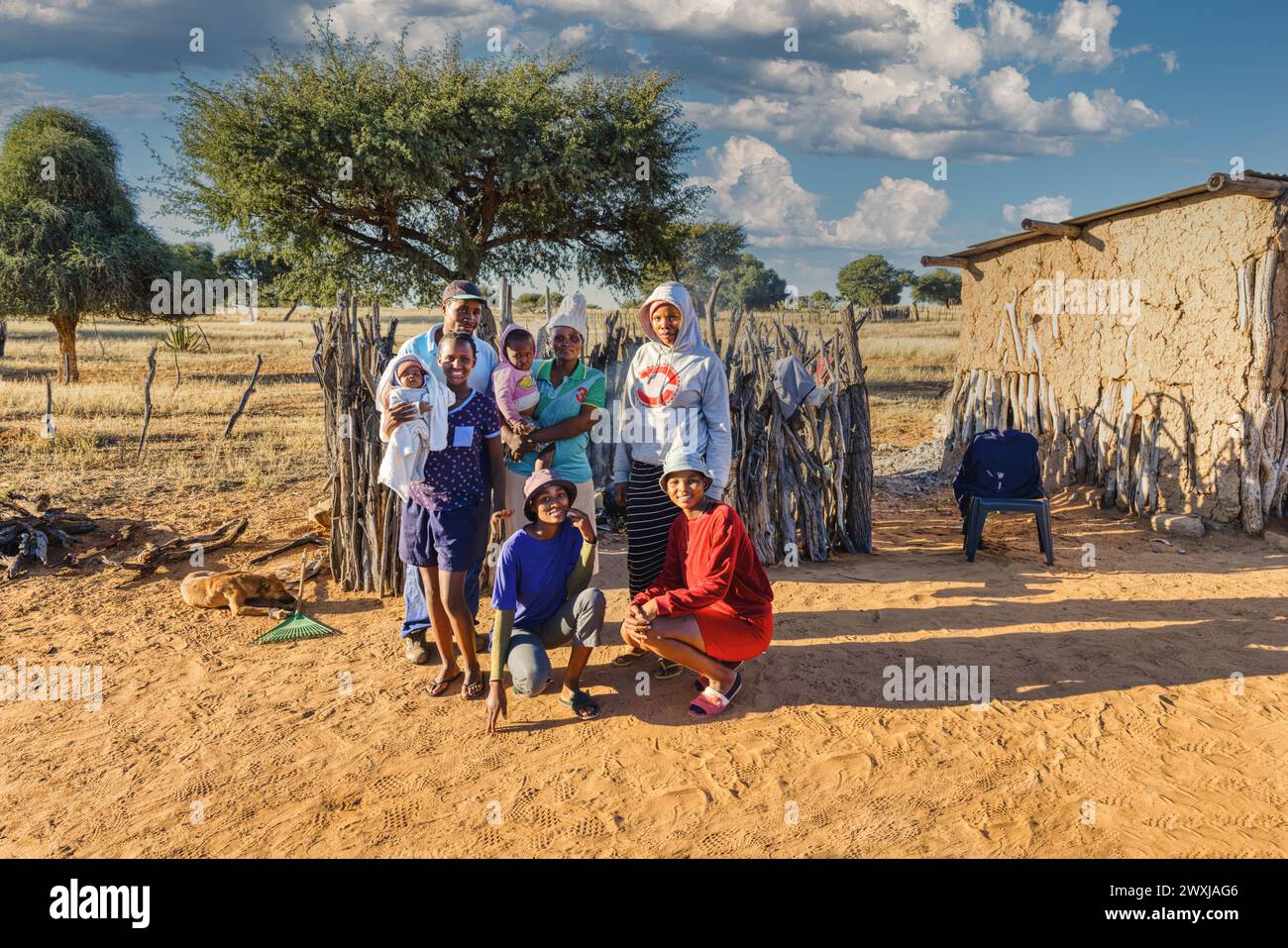 large african family in the village in front of the outdoors kitchen ...