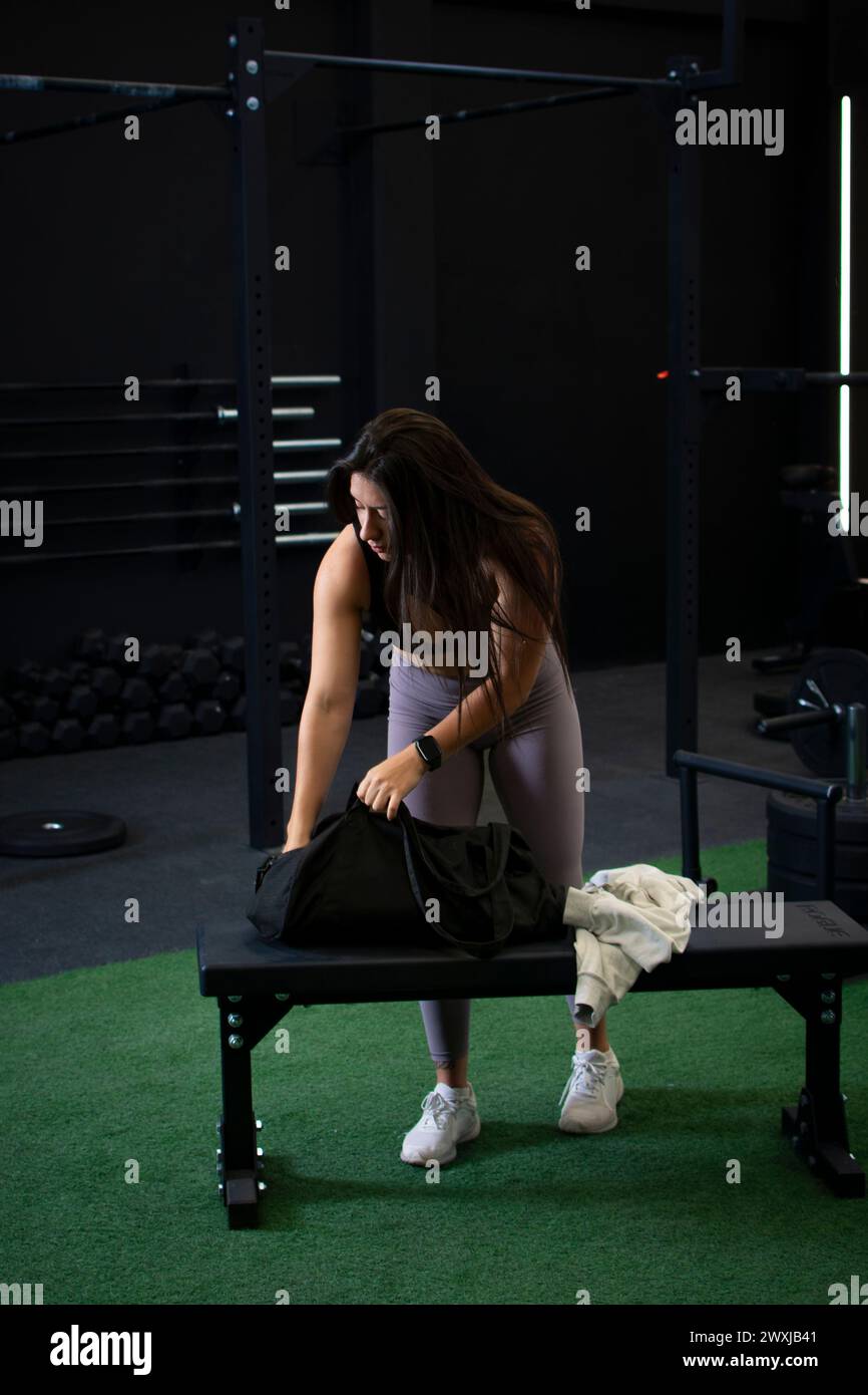 Female athlete searching through her backpack as she prepares to train ...
