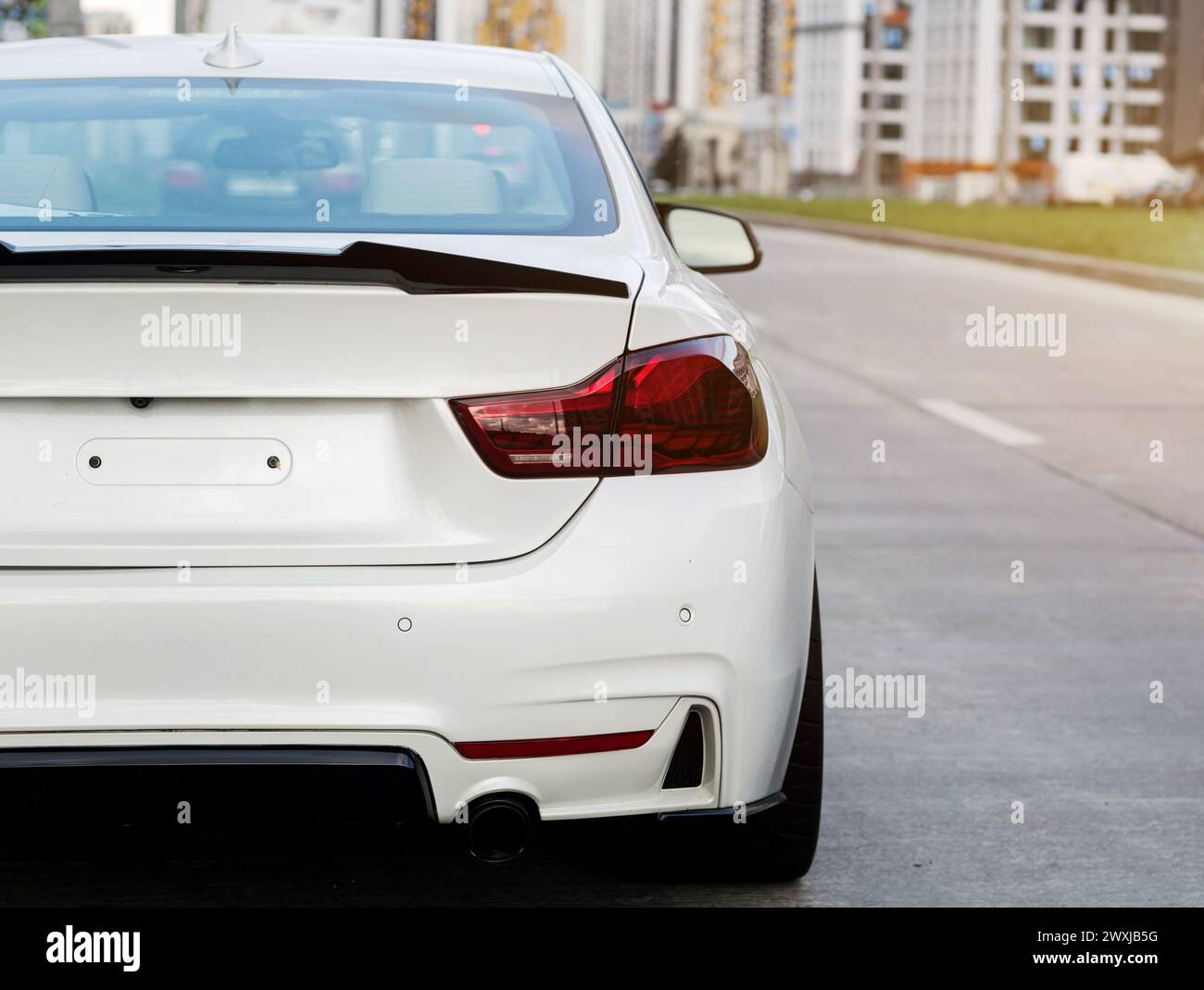 White car back view with taillights off. elegant auto in city Stock ...