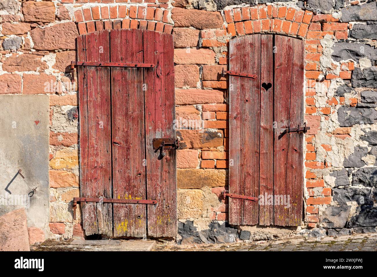 Weathered wooden doors to stable and loo, with heart, facade made of ...