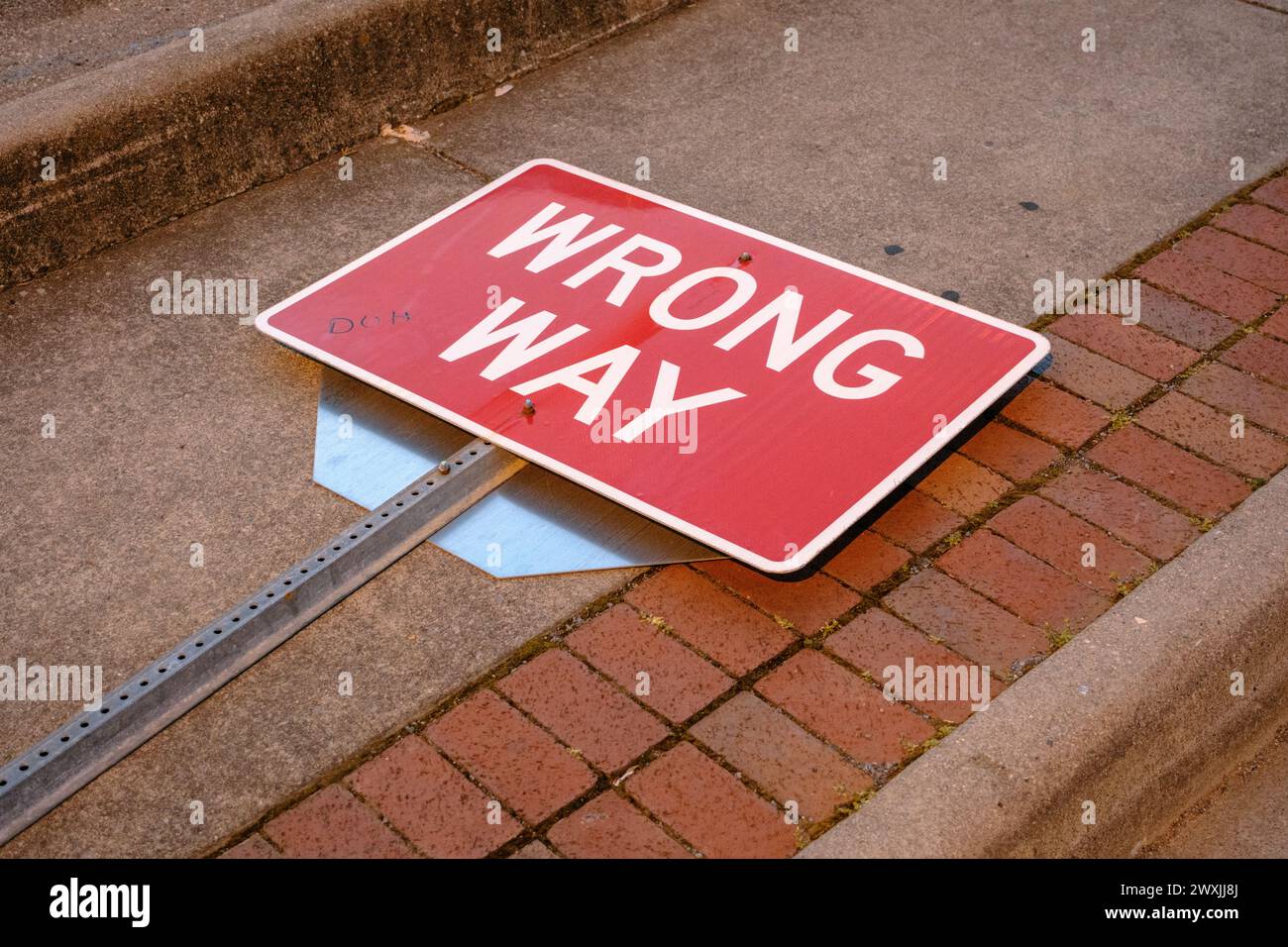 Wrong Way sign laying on the sidewalk in Marion, Virginia Stock Photo ...