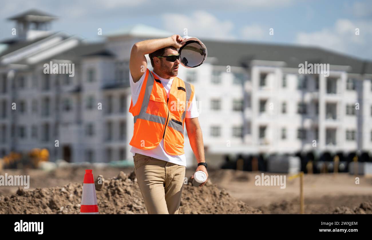 Tired worker. 40s worker builder man on site construction. American middle aged man worker ...