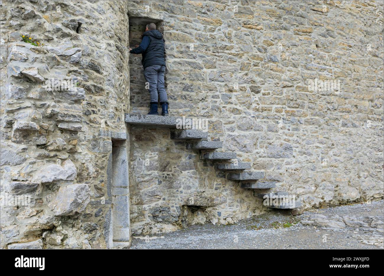 A male at the top of some ancient stone steps attached to the side of a ...