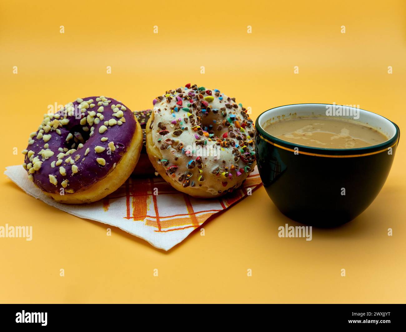 coffee and donuts on yellow background Stock Photo - Alamy