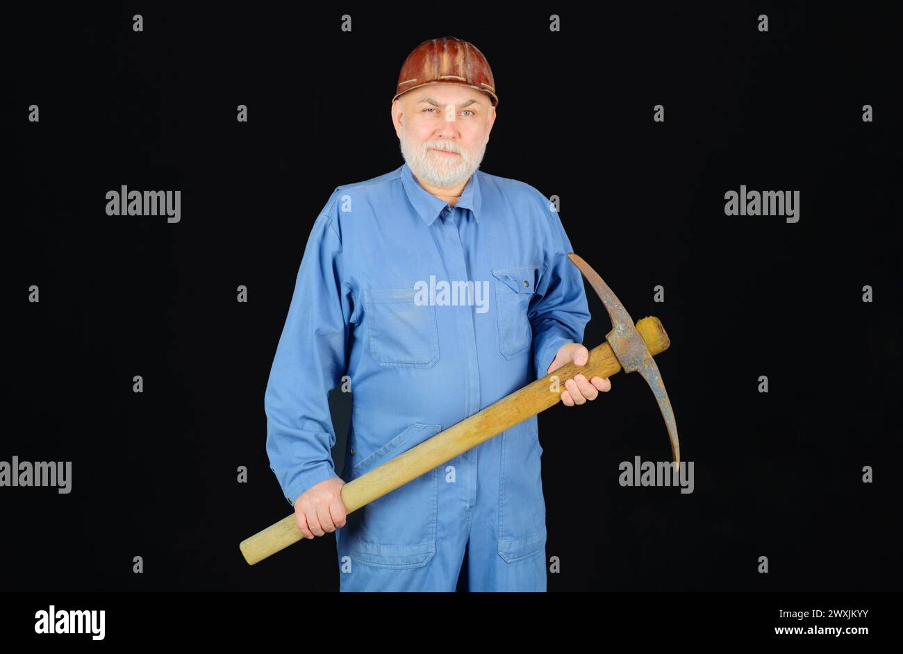 Construction and building works. Bearded man in coveralls and hard hat ...