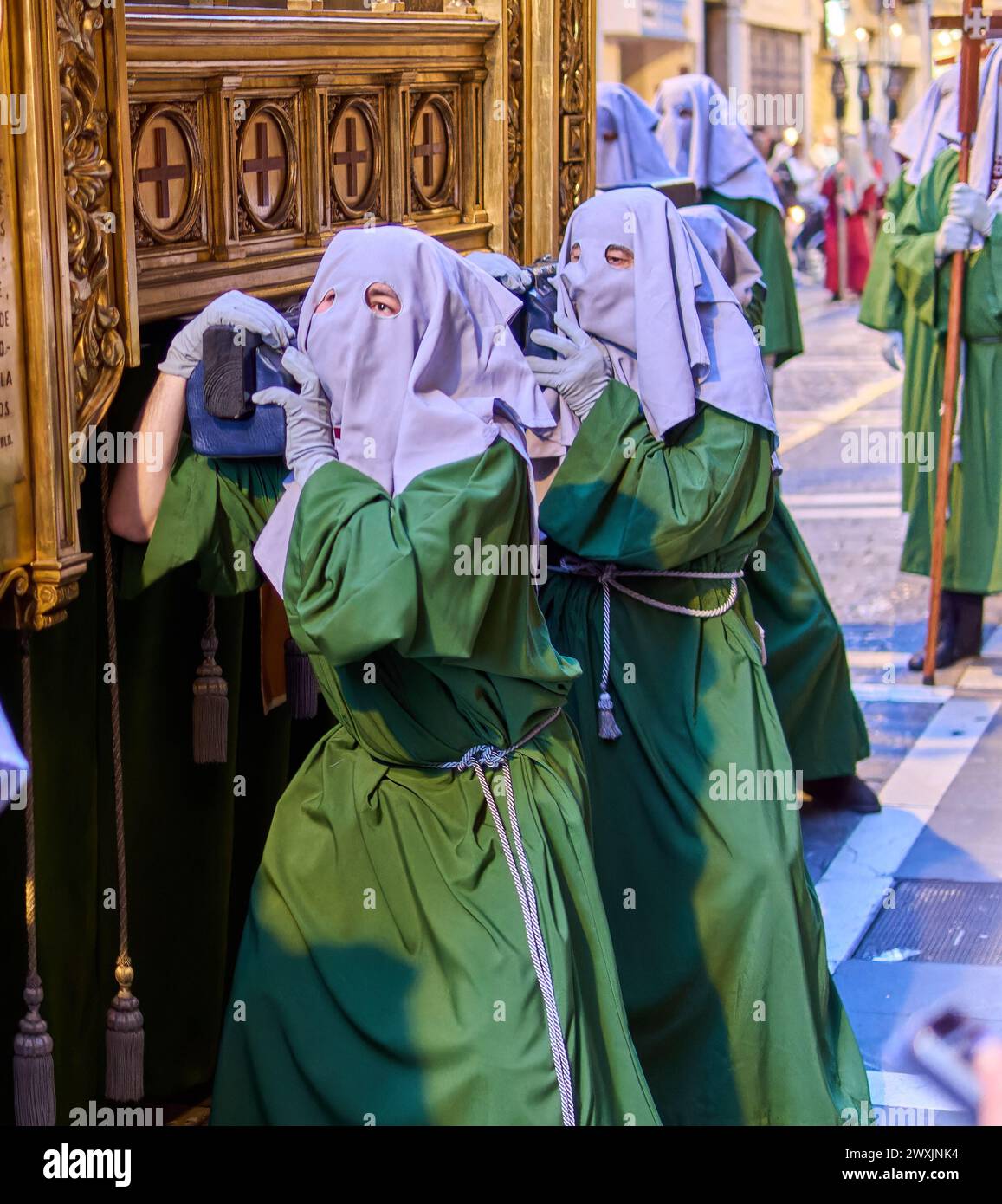 Religious Procession with Individuals in Green Robes Carrying an Ornate ...