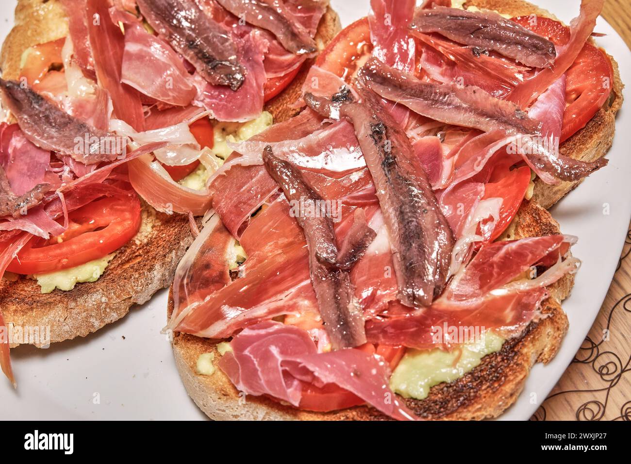 Crunchy toasts topped with delicious Iberian ham, juicy tomato slices ...