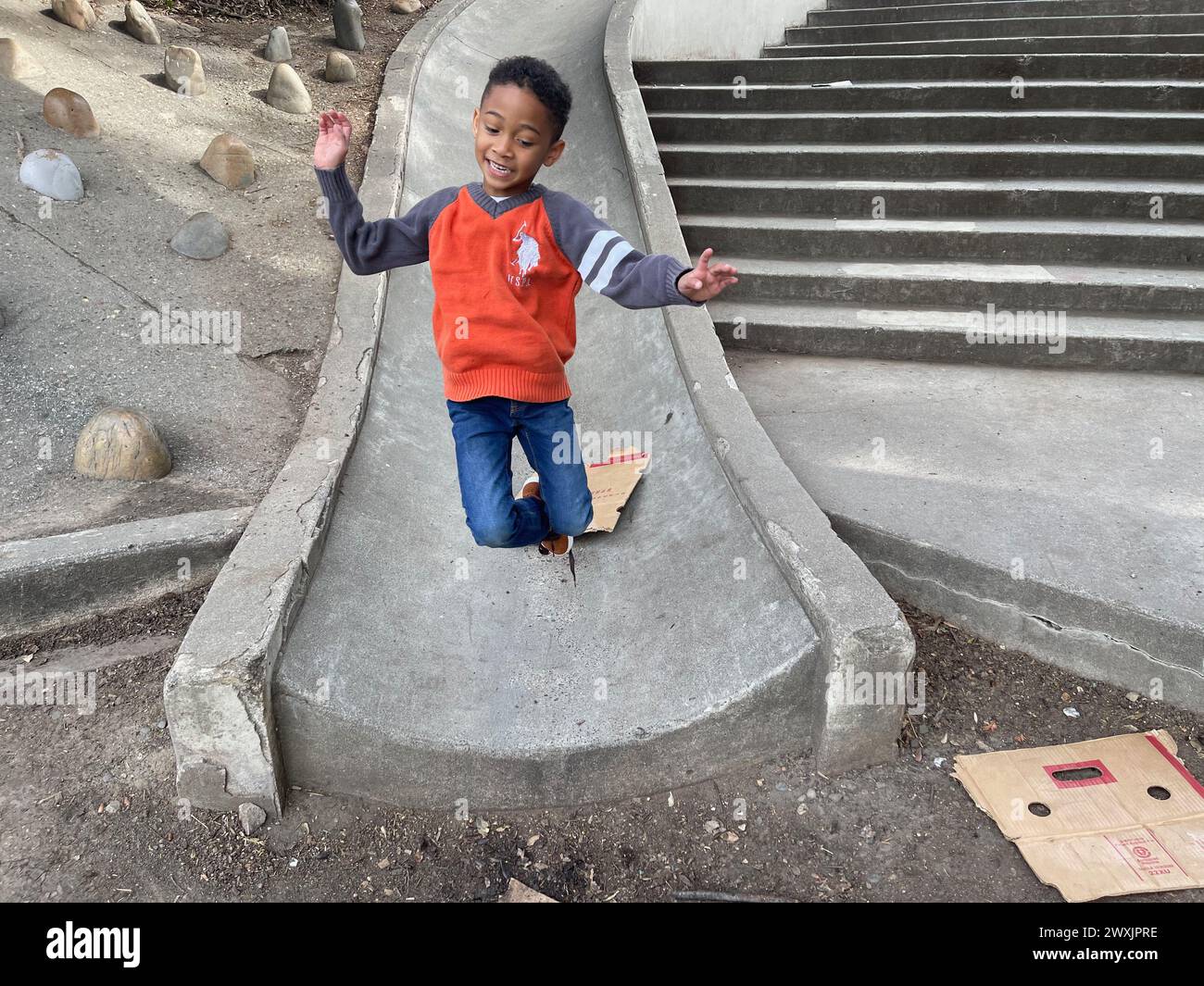 A young boy skateboarding down a ramp by stairs Stock Photo - Alamy