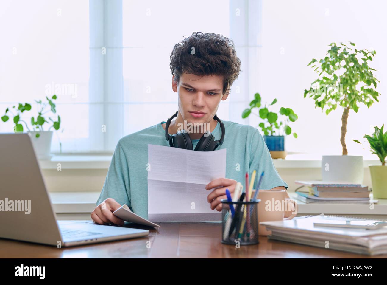 Serious young guy reading letter, paper document Stock Photo - Alamy