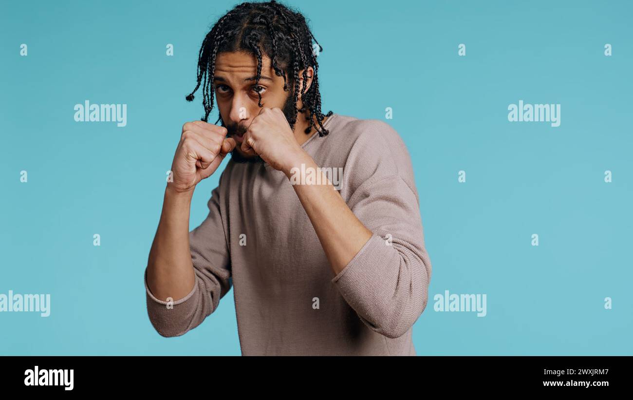 Middle Eastern man pretending to fight, throwing punches, holding ...