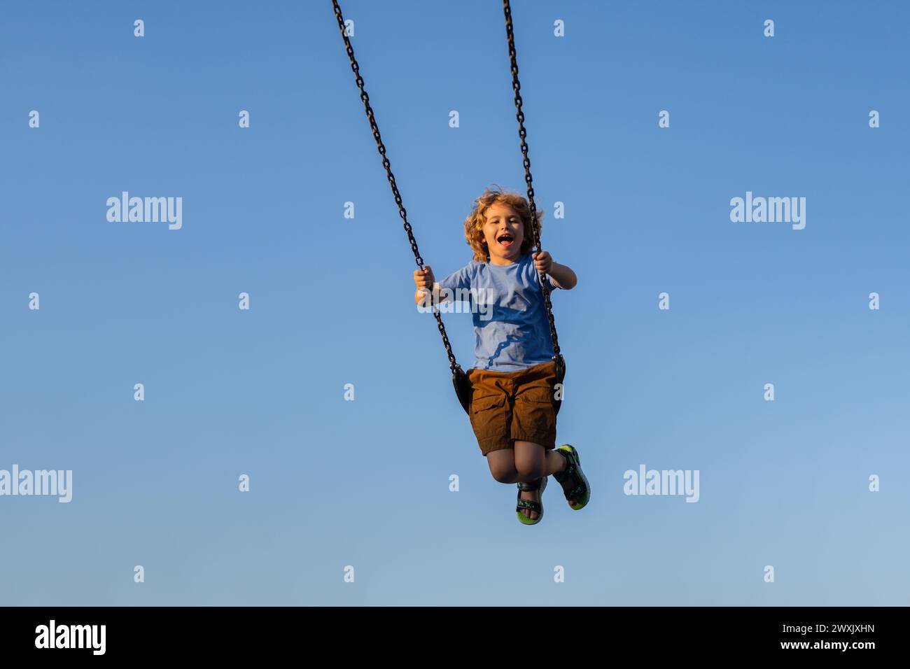 Joyful kid swinging on a swing. Happiness children. Child extreme ...