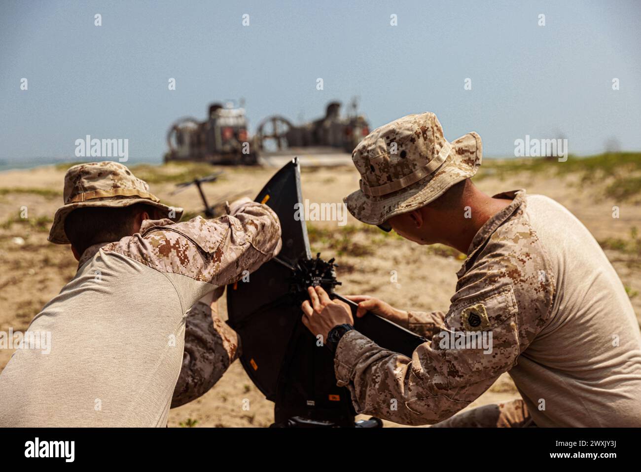 U.S. Marine Corps Sgt. Colton Harvey, left, a satellite communication ...