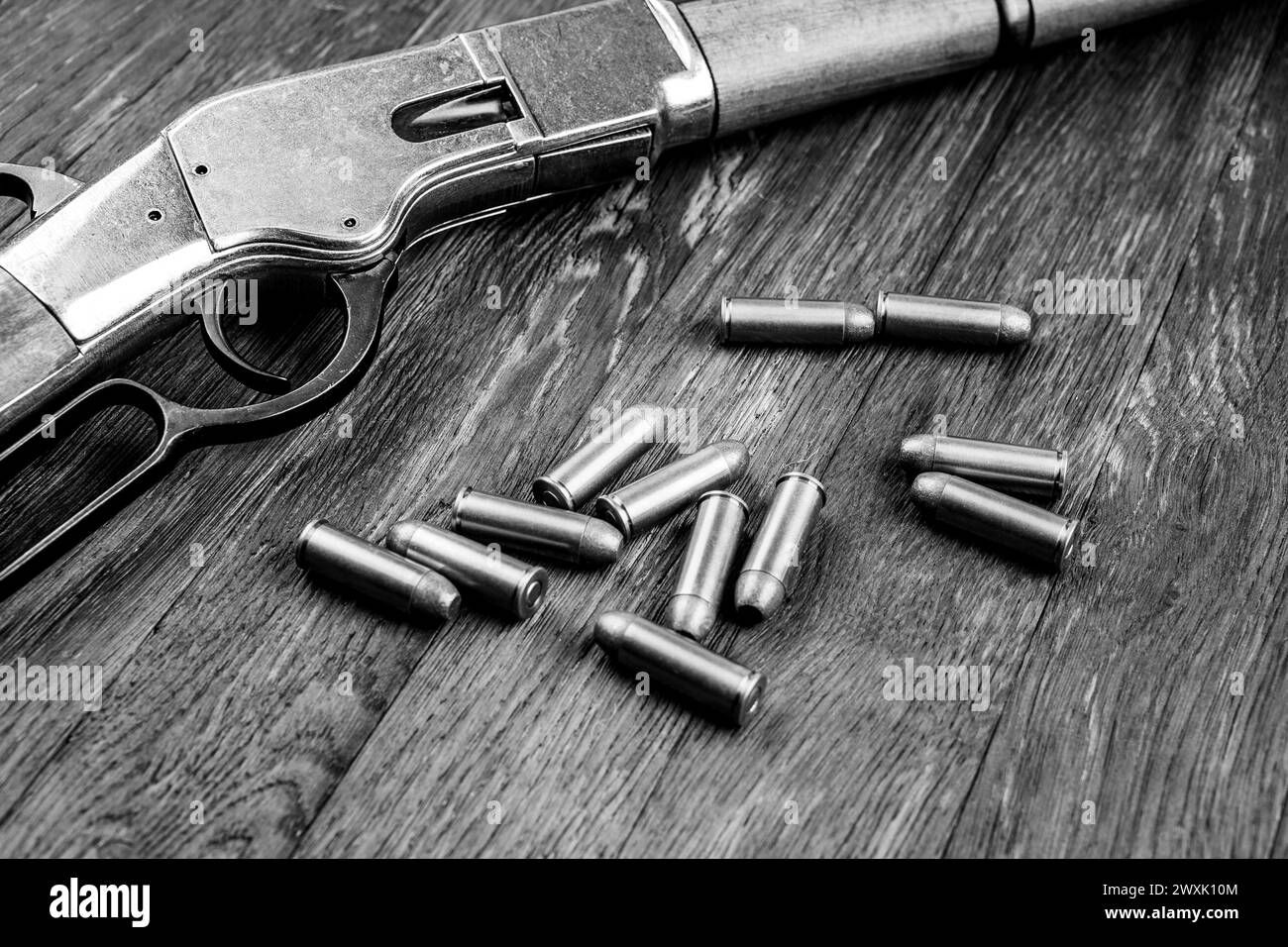 Old west rifle and ammunition on wooden table. Black and white Stock ...
