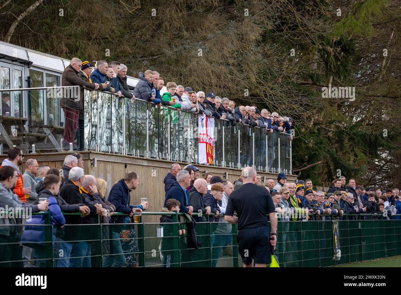 Linesman and spectators watch the football match at non league side ...