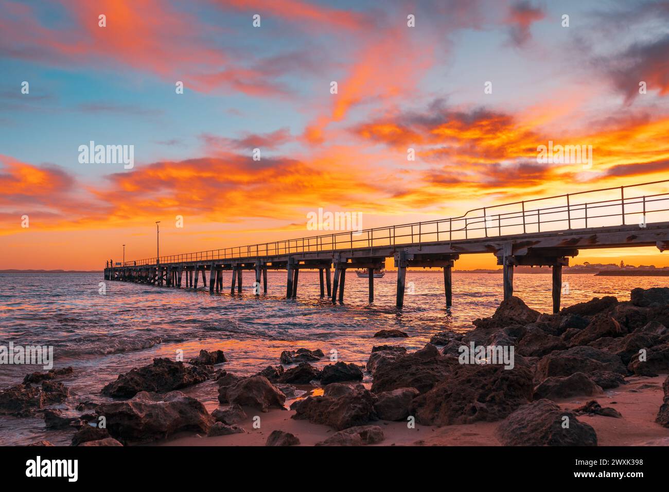 Robe pier with fishermen during early morning sunrise viewed from the ...