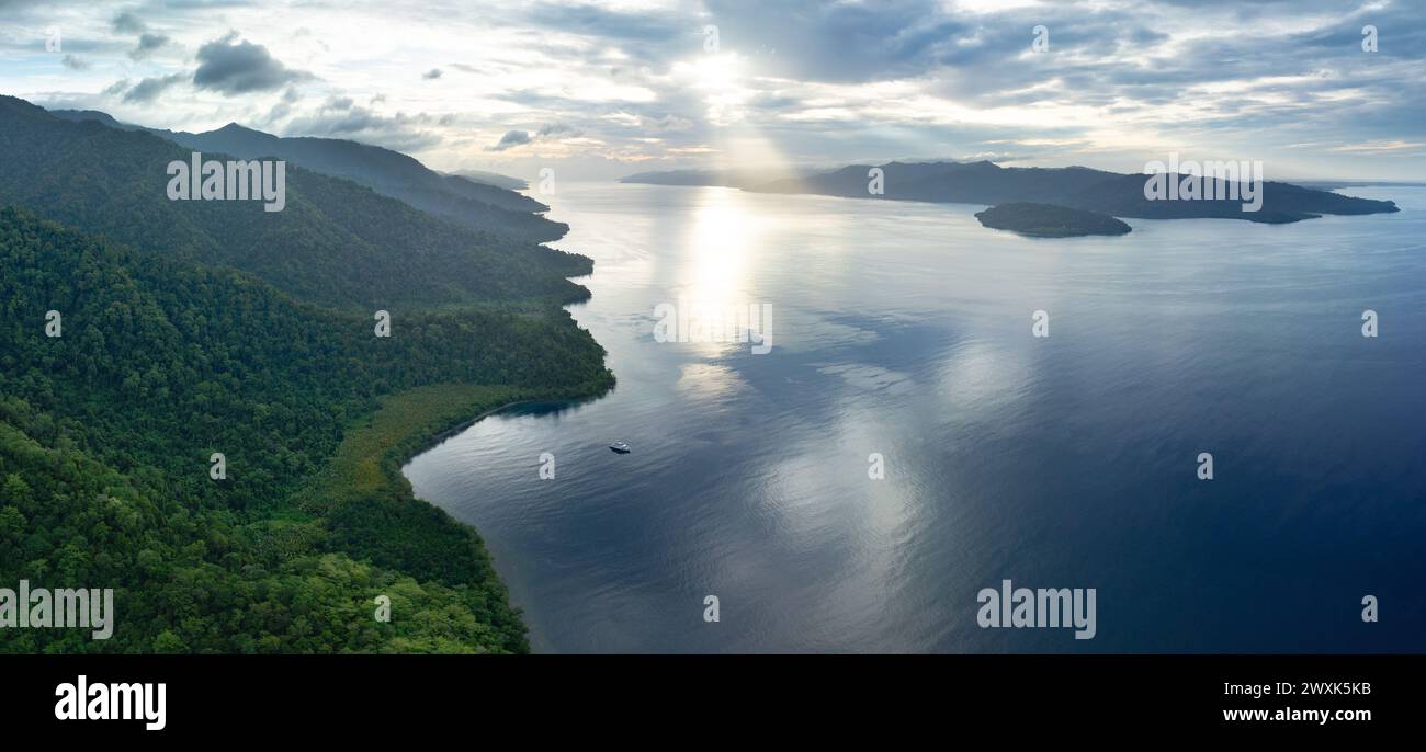 Thick rainforest covers the scenic coast of southern Batanta, Raja ...