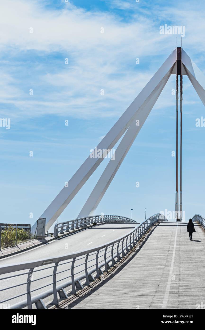 A small cable-stayed bridge with a pedestrian walking on the pedestrian ...