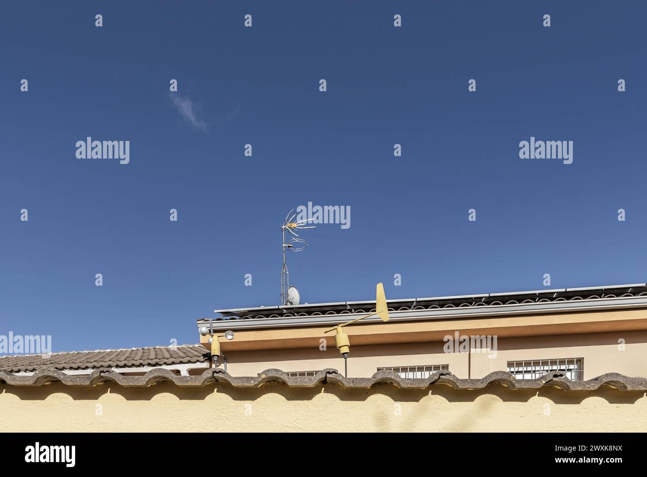 Roof of a house with an anemometer, a weather vane and some television ...
