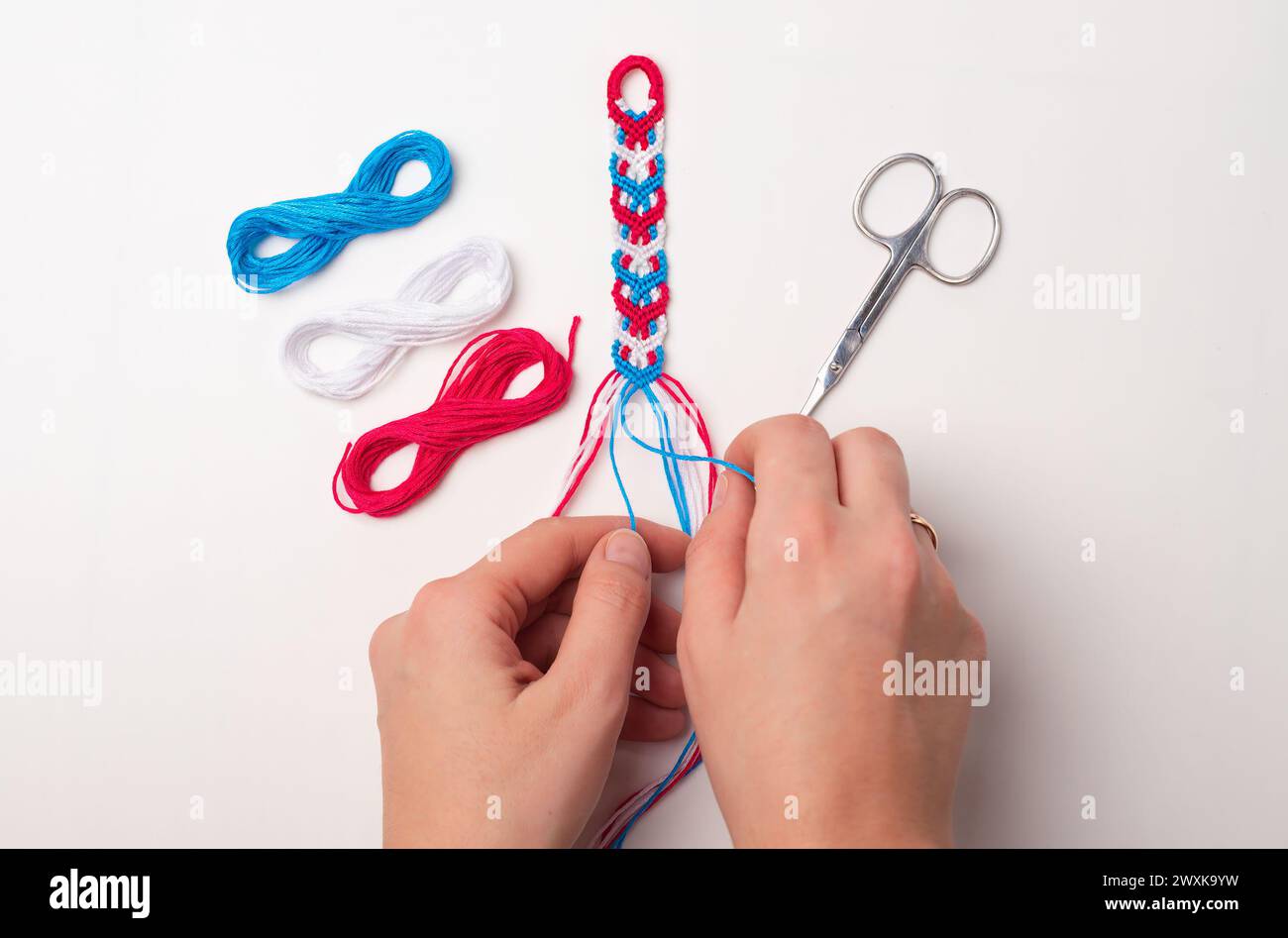 Process of weaving knot for DIY friendship bracelet. Female hands. step ...