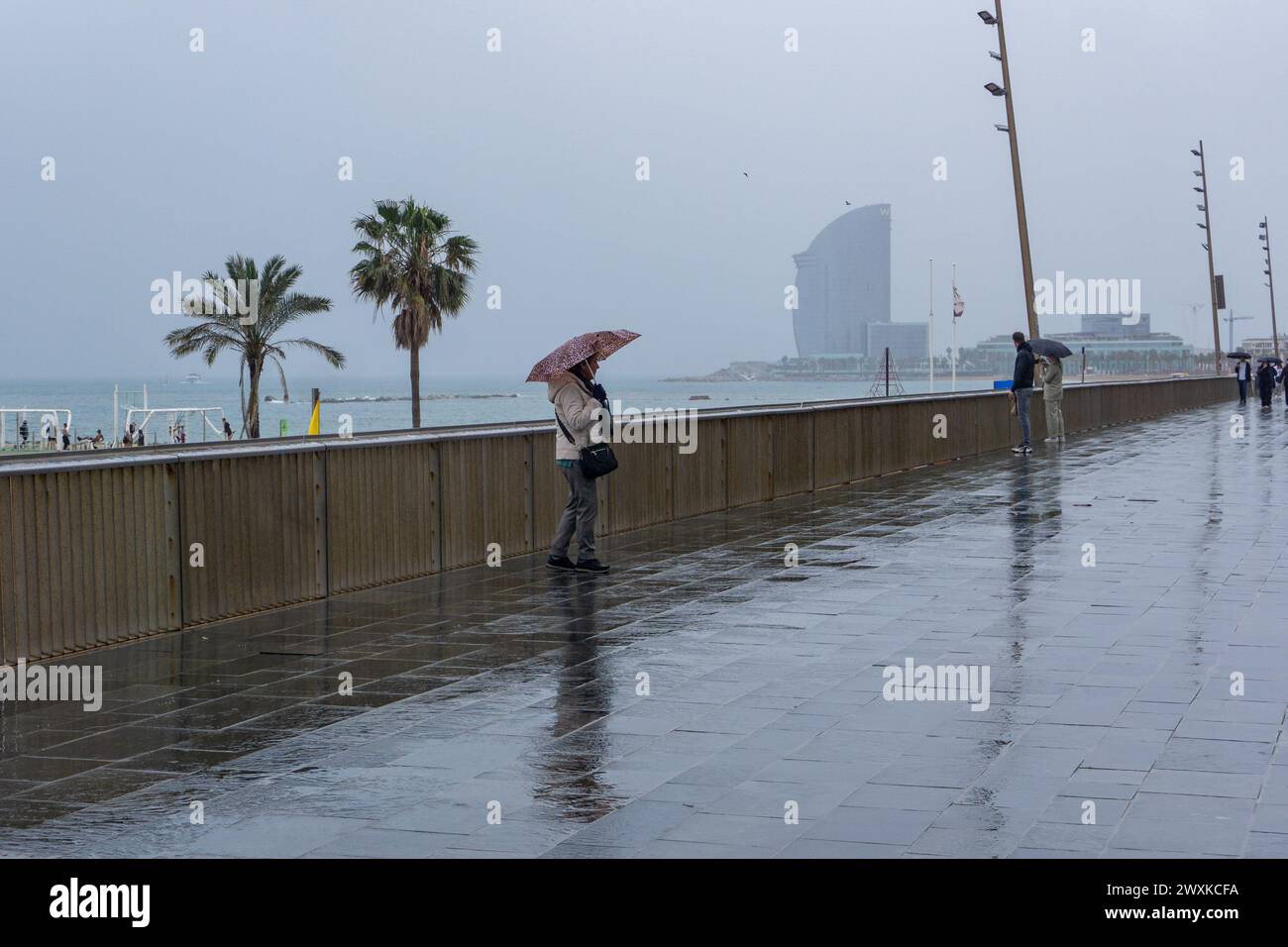 Barcelona, Spain. 31st Mar, 2024. A woman walks through Barceloneta and ...