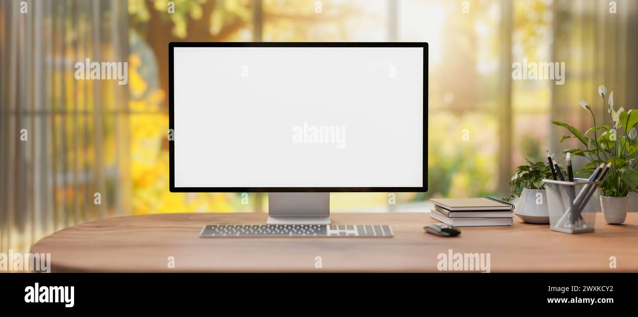 A computer white-screen mockup and accessories on a wooden desk in a ...