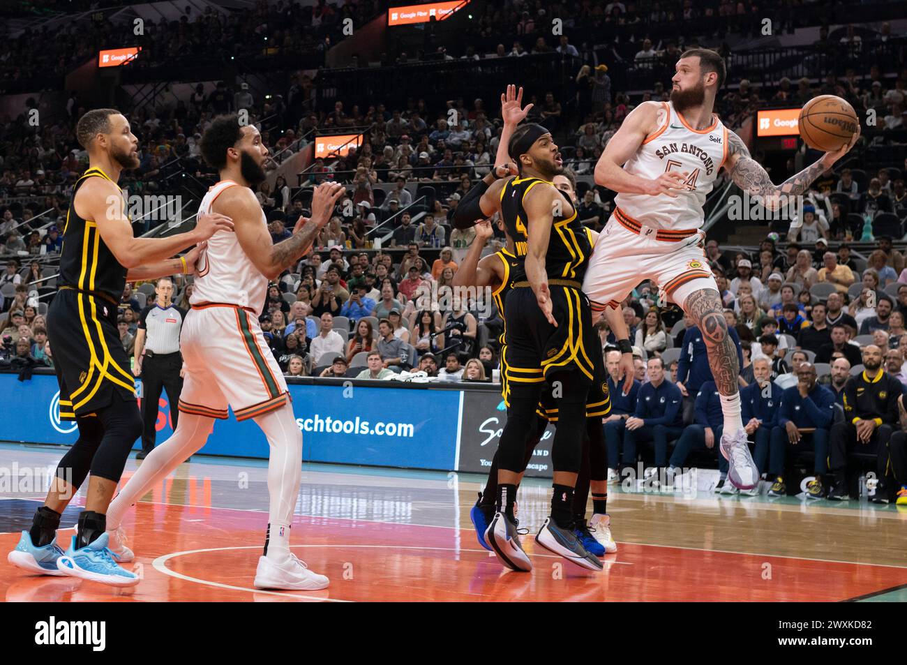 San Antonio Spurs' Sandro Mamukelashvili (54) tangles with Golden State Warriors' Moses Moody (4 ...