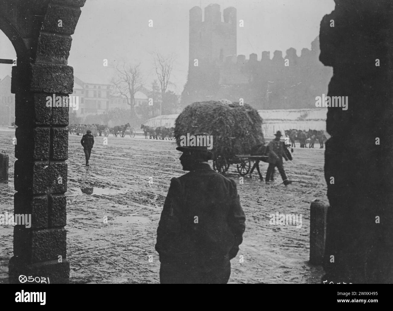 Horse drawn wagon carrying a load of hay through the streets of ...
