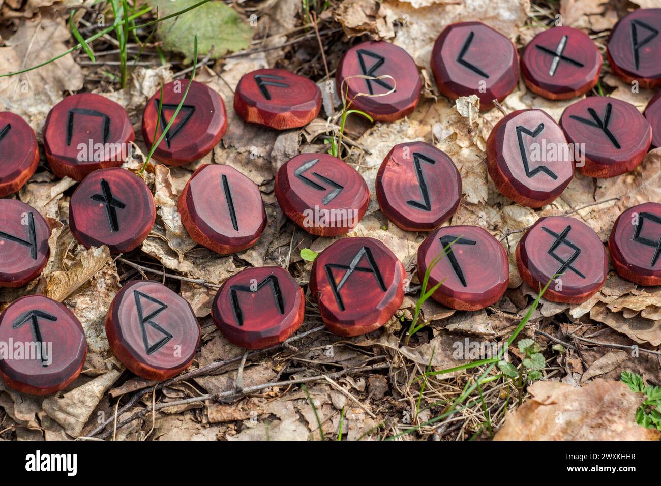 Red runes carved from wood on the ground Stock Photo - Alamy